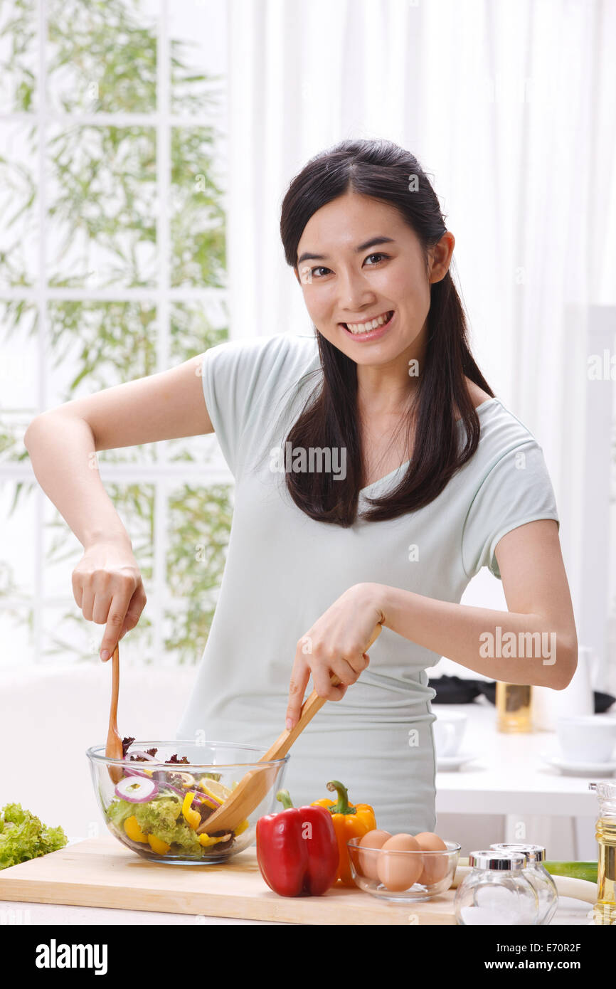 Young woman cooking in kitchen Stock Photo - Alamy