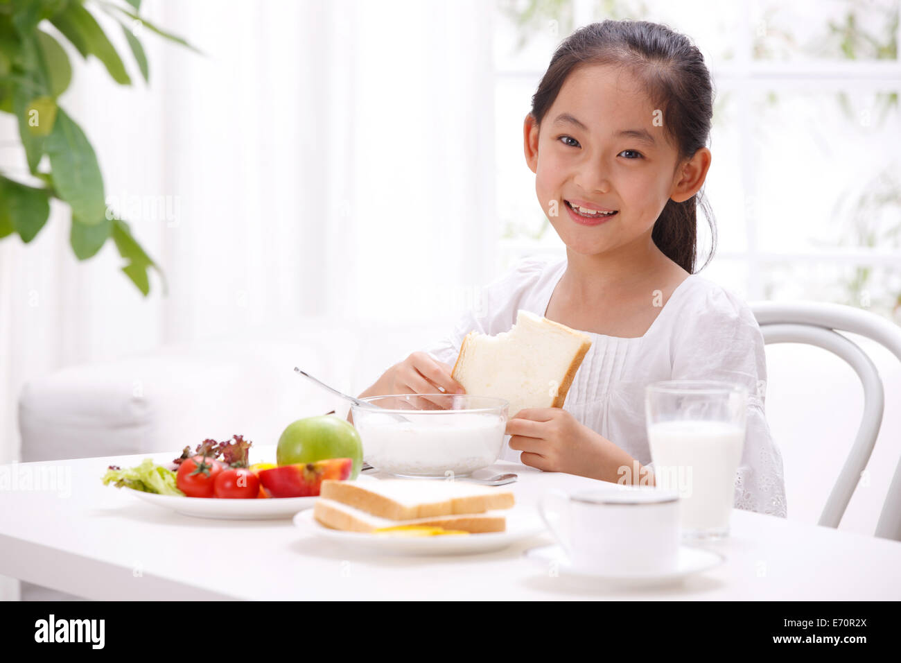 Girl having breakfast in kitchen Stock Photo - Alamy
