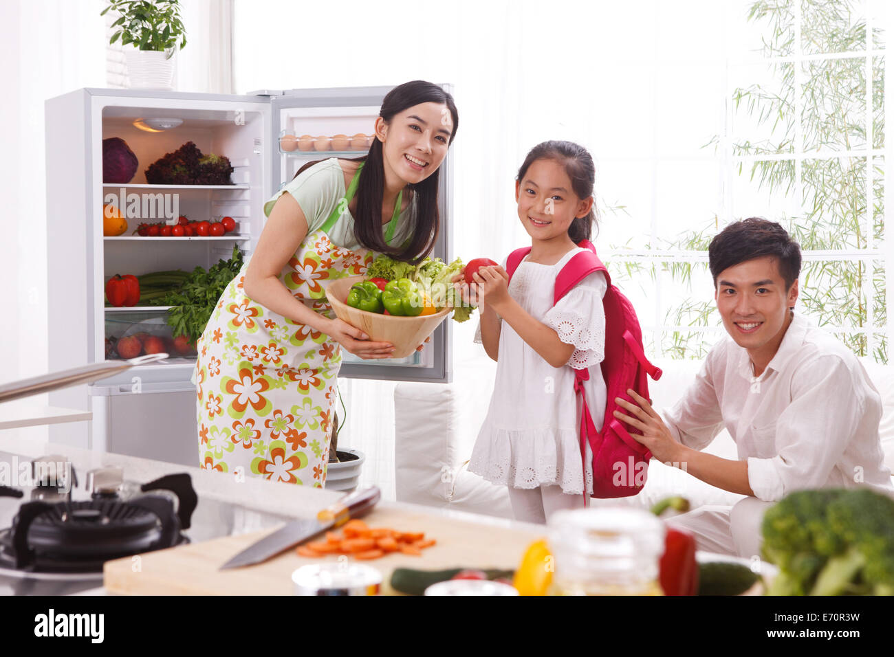 Family holding vegetables in kitchen Stock Photo - Alamy