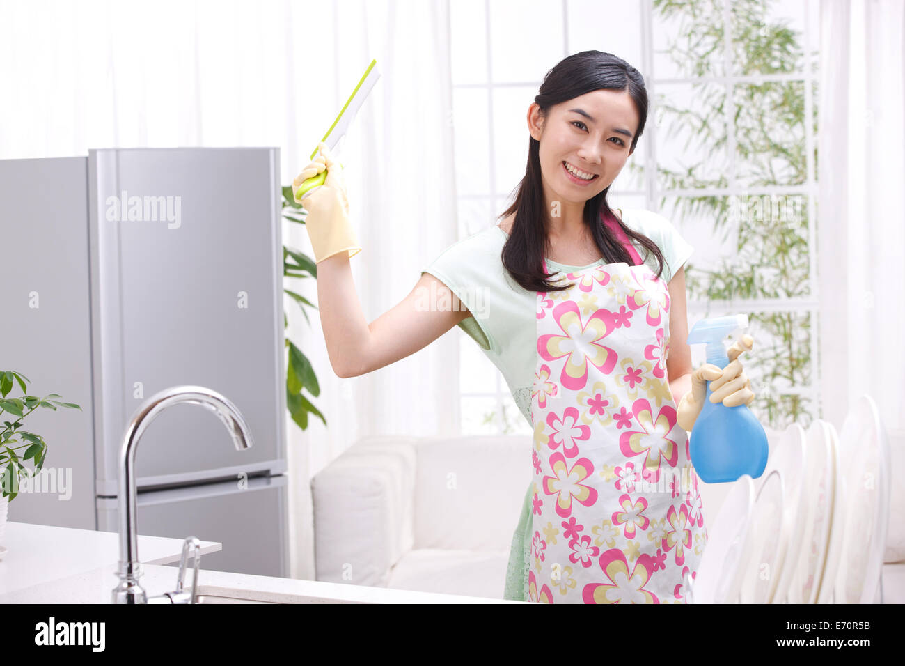 Young woman cleaning kitchen Stock Photo - Alamy