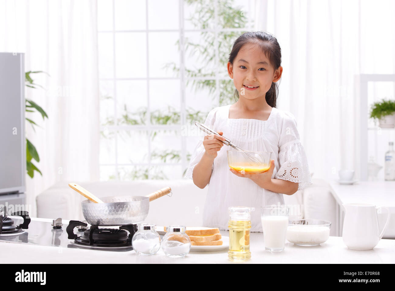 Girl cooking in kitchen Stock Photo - Alamy