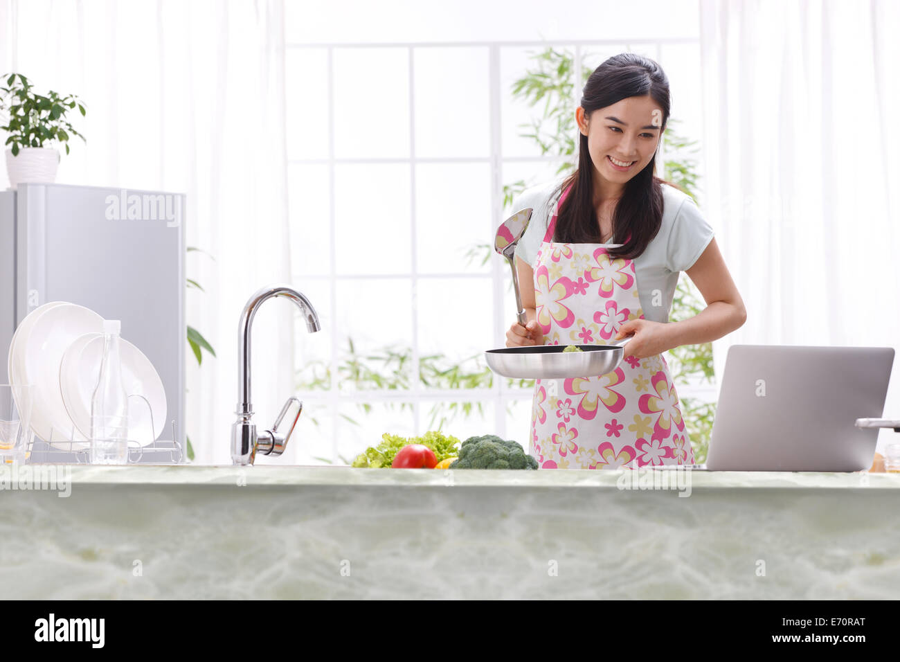 Young woman learning cooking in kitchen Stock Photo - Alamy