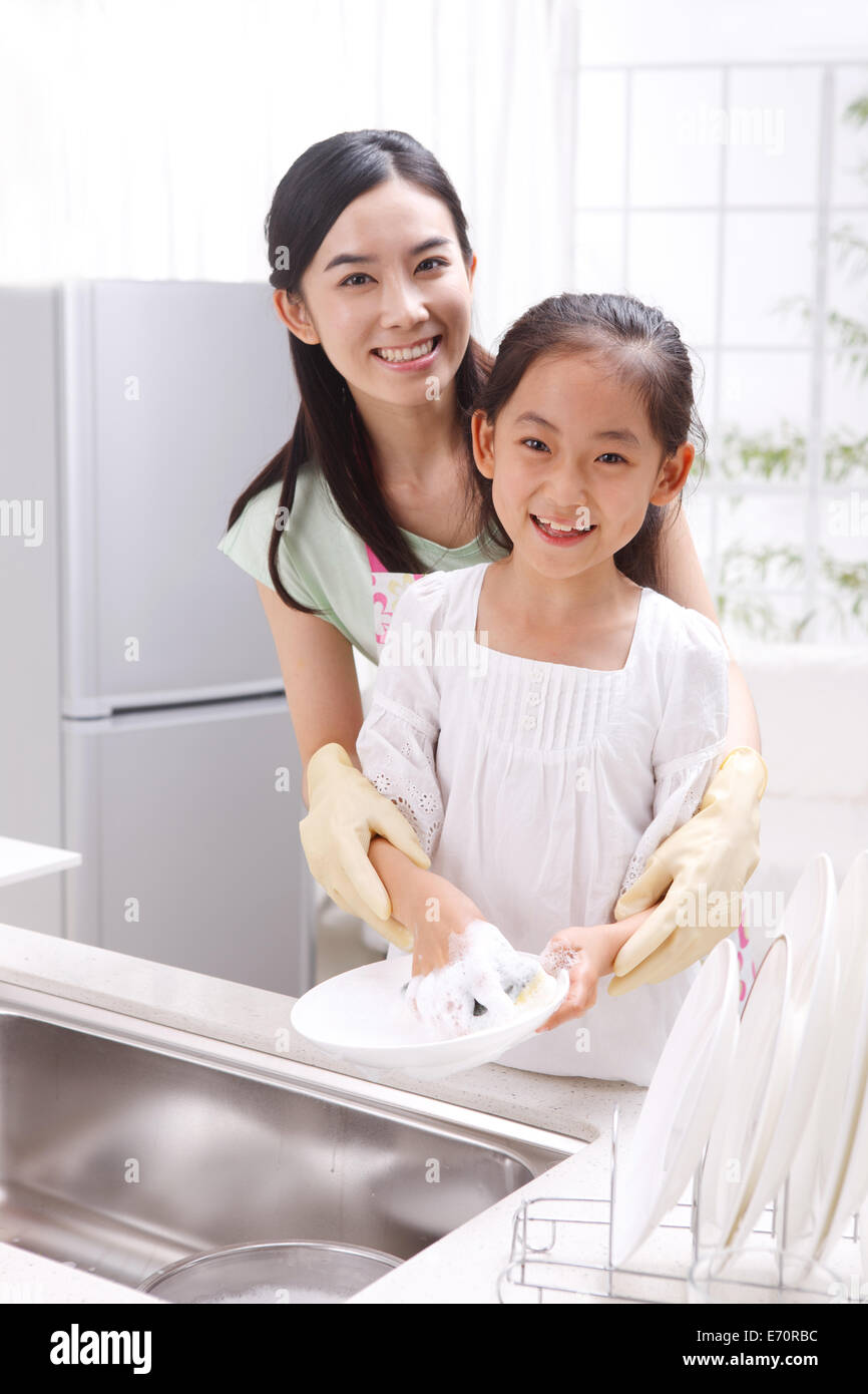 Mother and daughter washing dishes in kitchen Stock Photo - Alamy