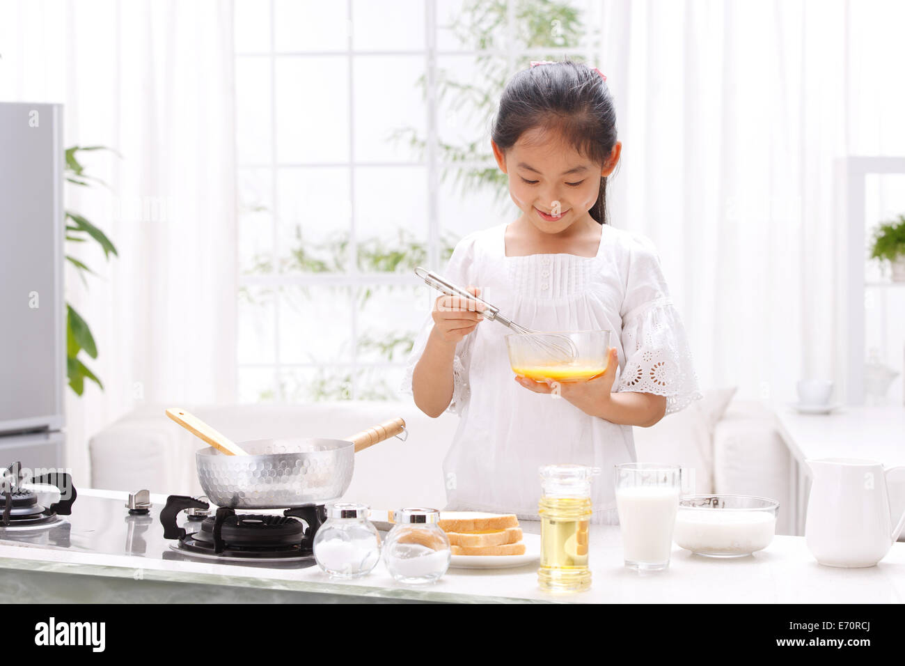 Girl cooking in kitchen Stock Photo - Alamy