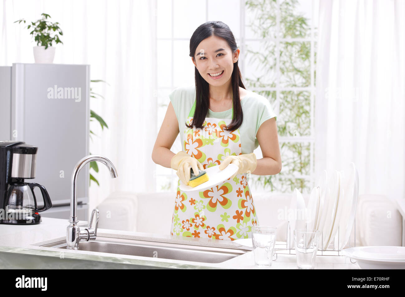 Young woman washing dishes in kitchen Stock Photo - Alamy
