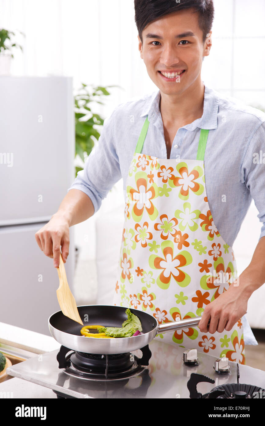 Young man cooking in kitchen Stock Photo - Alamy