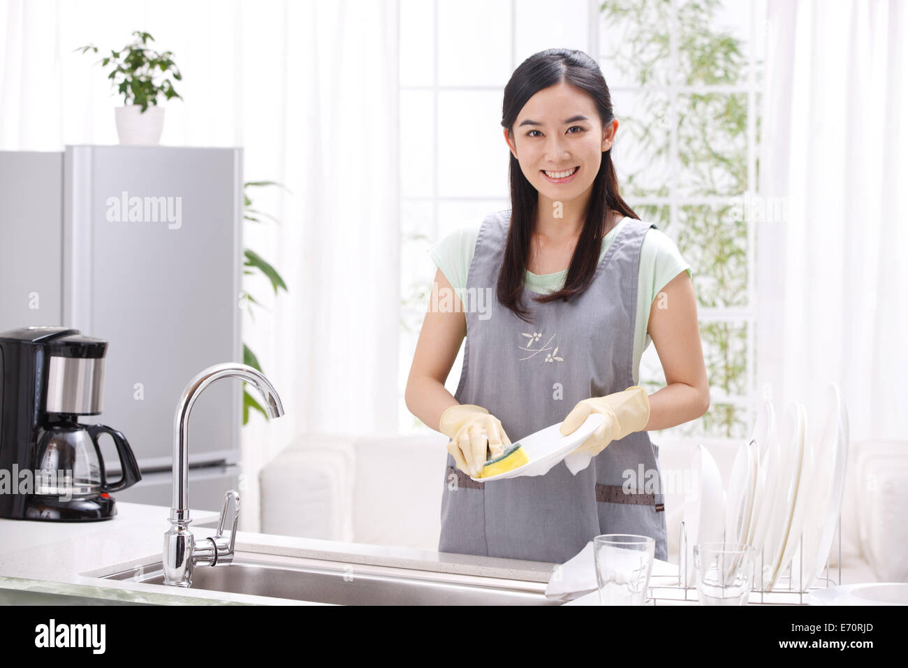Young woman washing dishes in kitchen Stock Photo - Alamy
