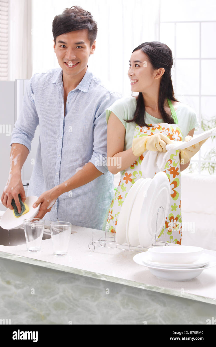 Young couple washing dishes in kitchen Stock Photo - Alamy