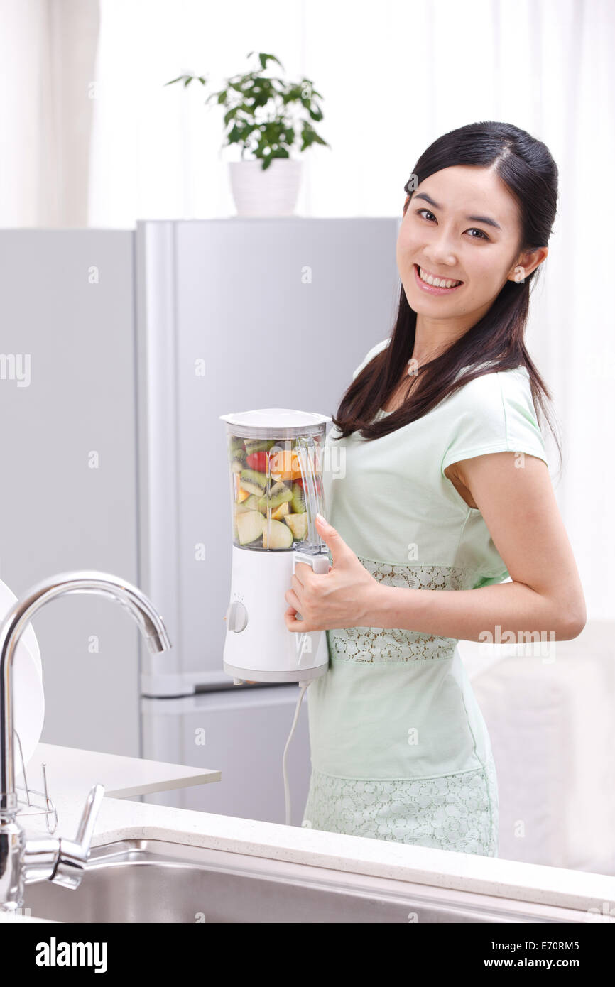 Young woman holding blender in kitchen Stock Photo - Alamy