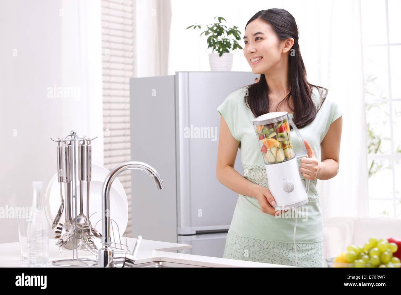 Young woman holding blender in kitchen Stock Photo - Alamy