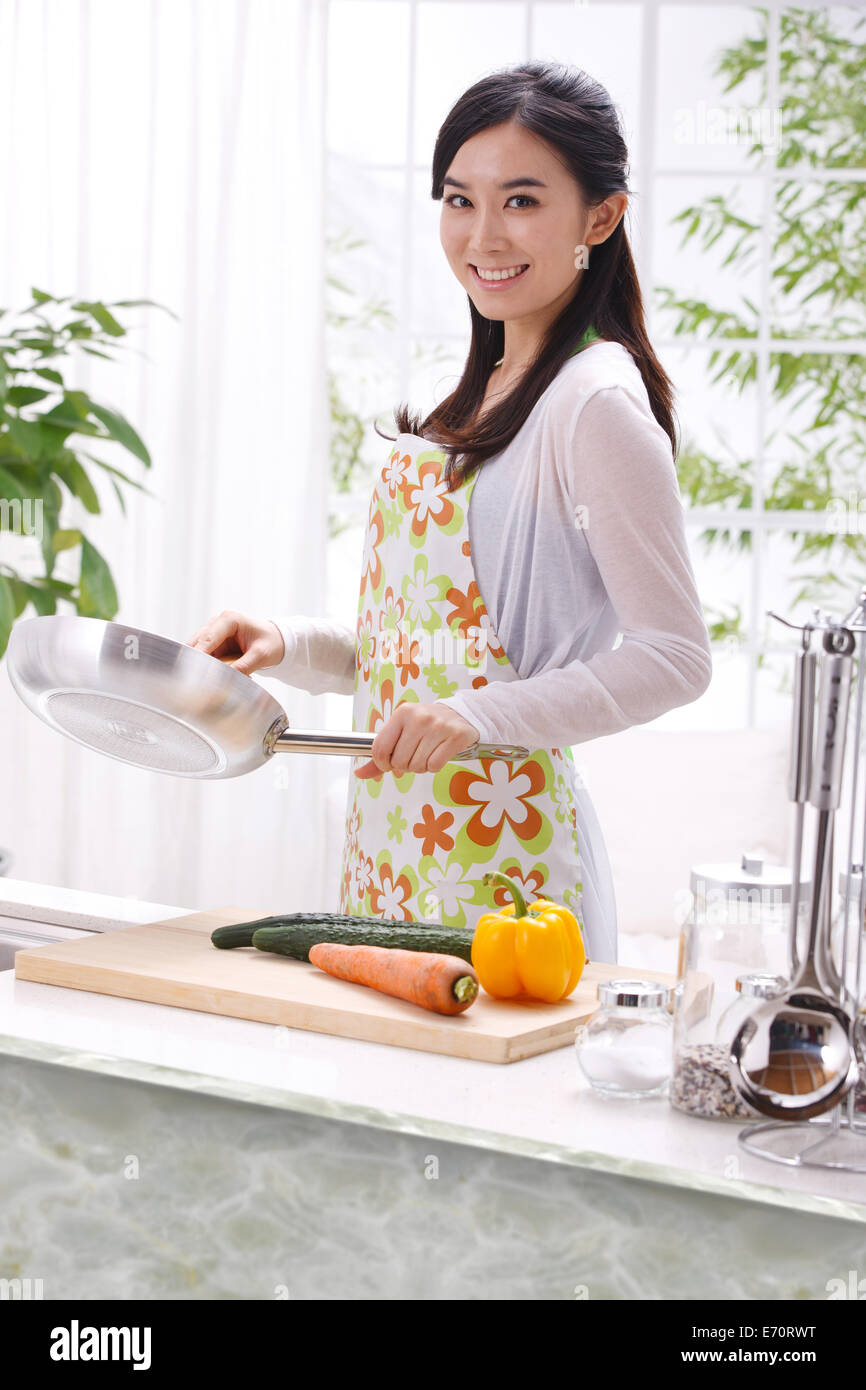 Young woman cooking in kitchen Stock Photo - Alamy
