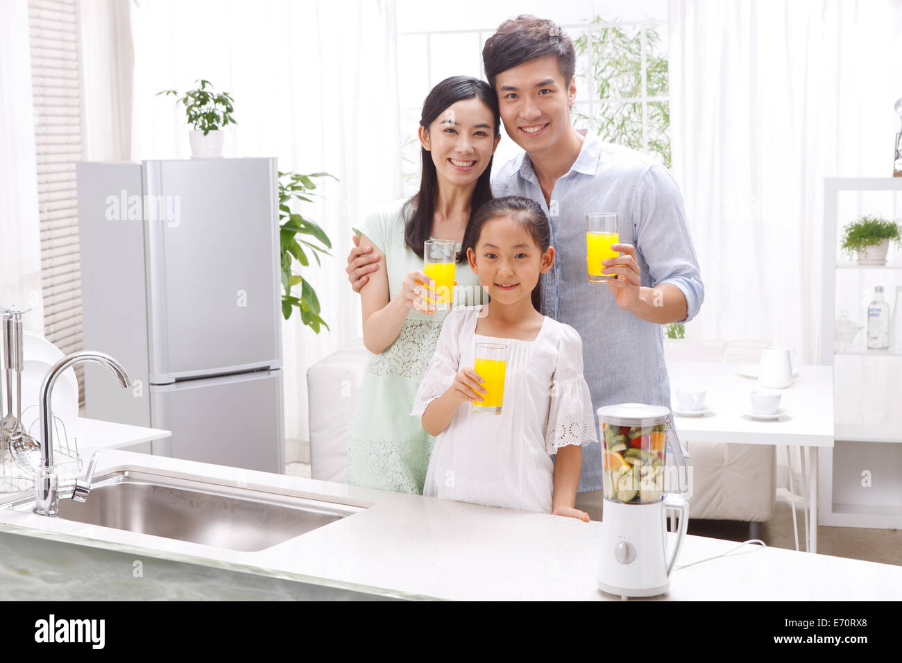 Family drinking juice in kitchen Stock Photo - Alamy