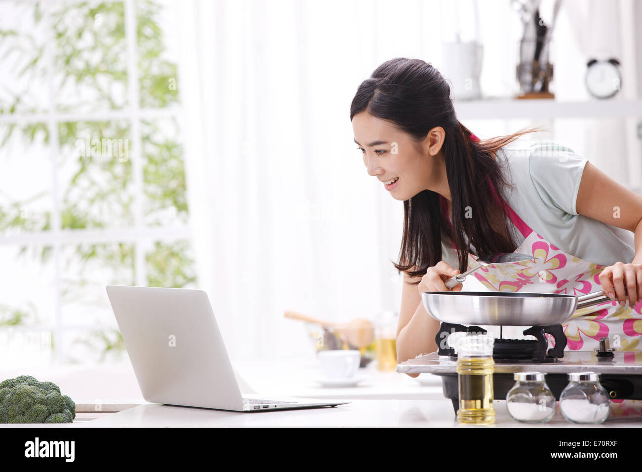 Young woman learning cooking in kitchen Stock Photo - Alamy