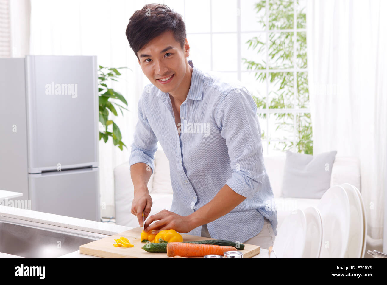 Young man cooking in kitchen Stock Photo - Alamy