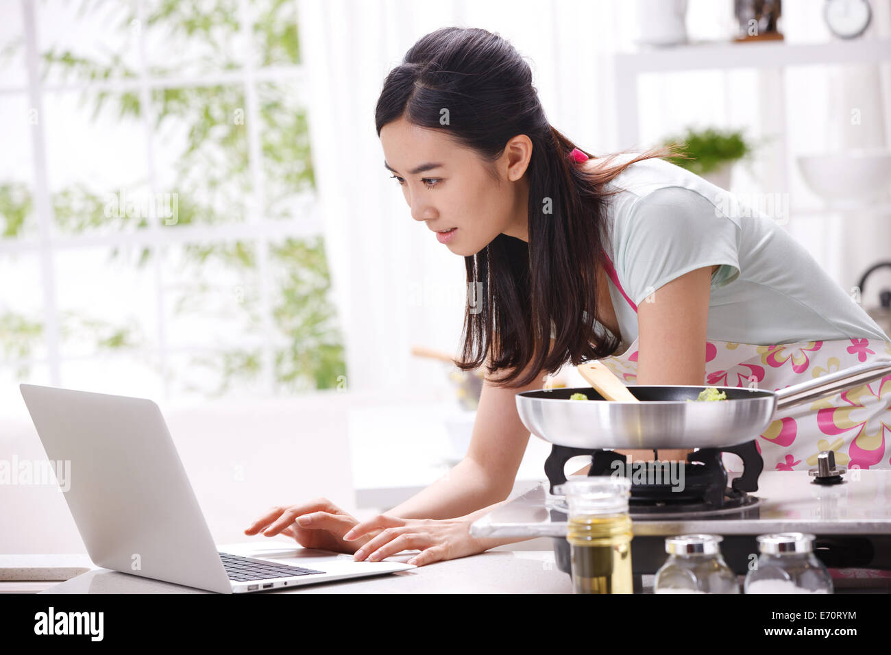 Young woman learning cooking in kitchen Stock Photo - Alamy