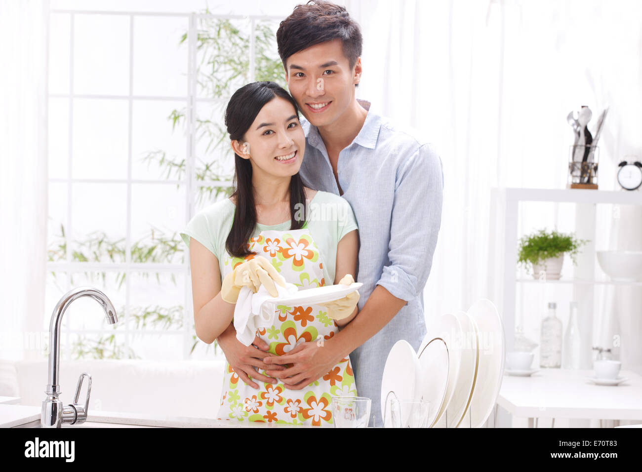 Young couple washing dishes in kitchen Stock Photo - Alamy