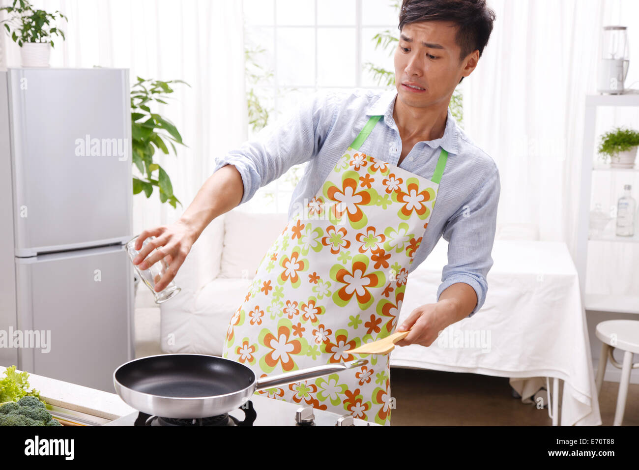 Young man cooking in kitchen Stock Photo - Alamy
