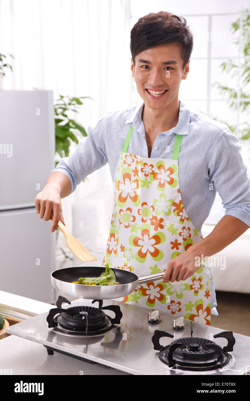 Young man cooking in kitchen Stock Photo - Alamy
