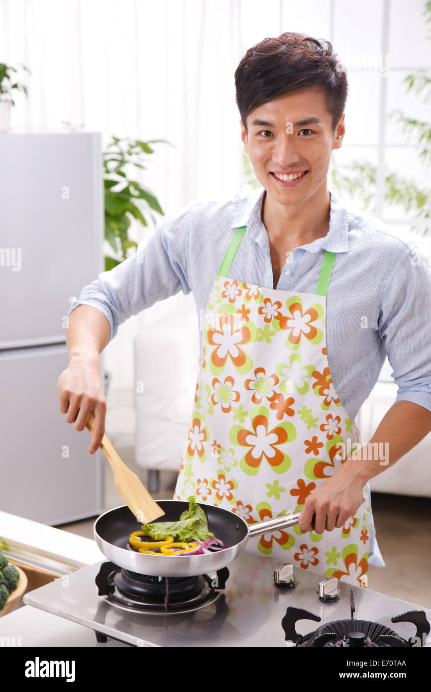 Young man cooking in kitchen Stock Photo - Alamy