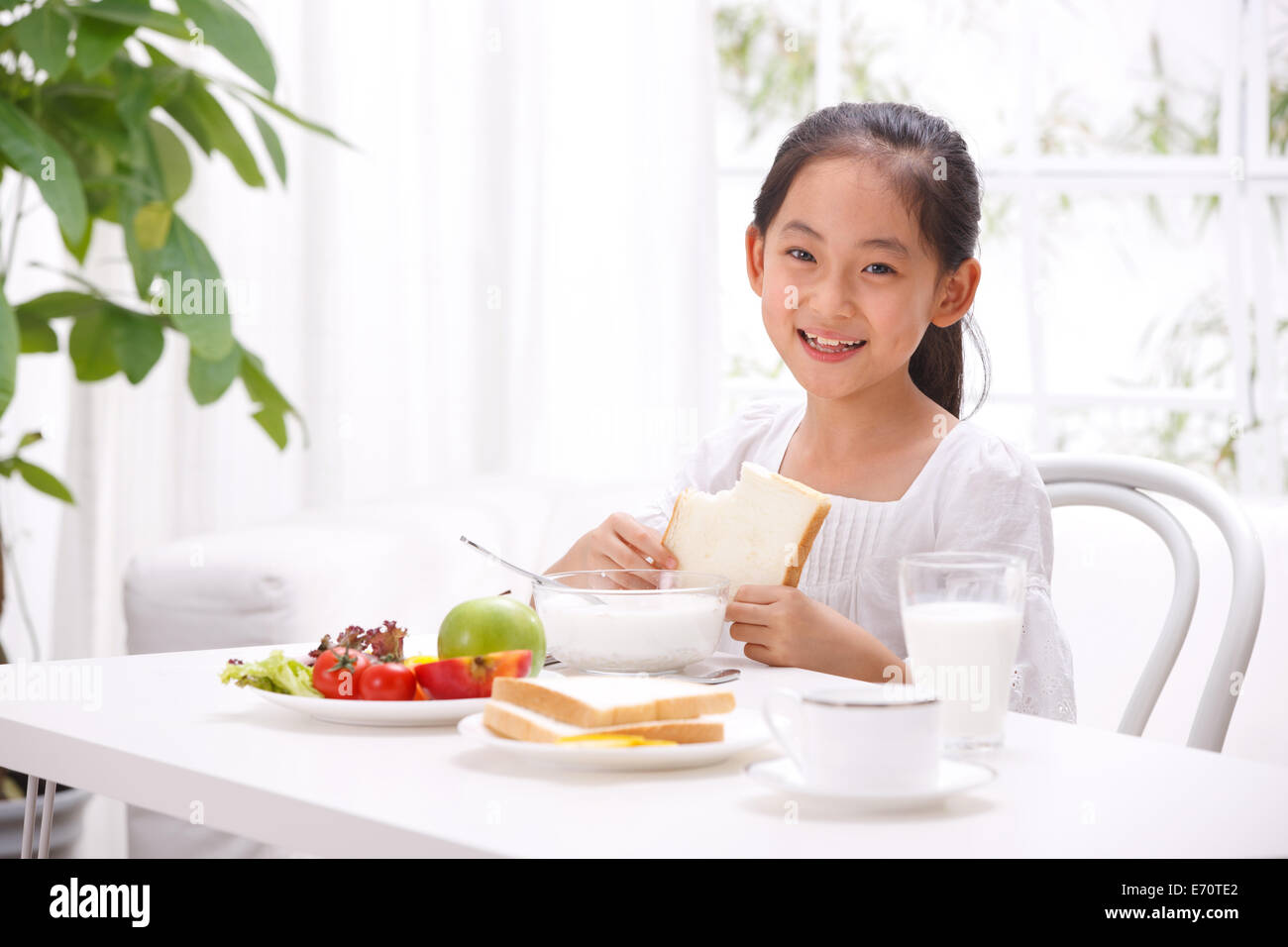 Girl having breakfast in kitchen Stock Photo - Alamy
