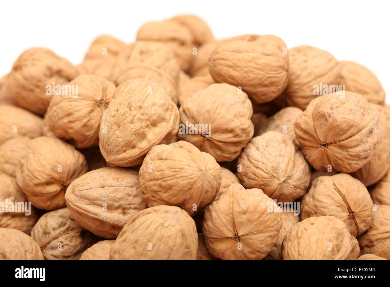 Walnuts heap against white background. Closeup Stock Photo - Alamy