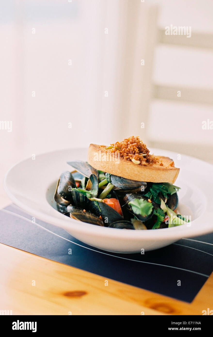 Mussels, shellfish on a white china dish. Garnishes Stock Photo - Alamy