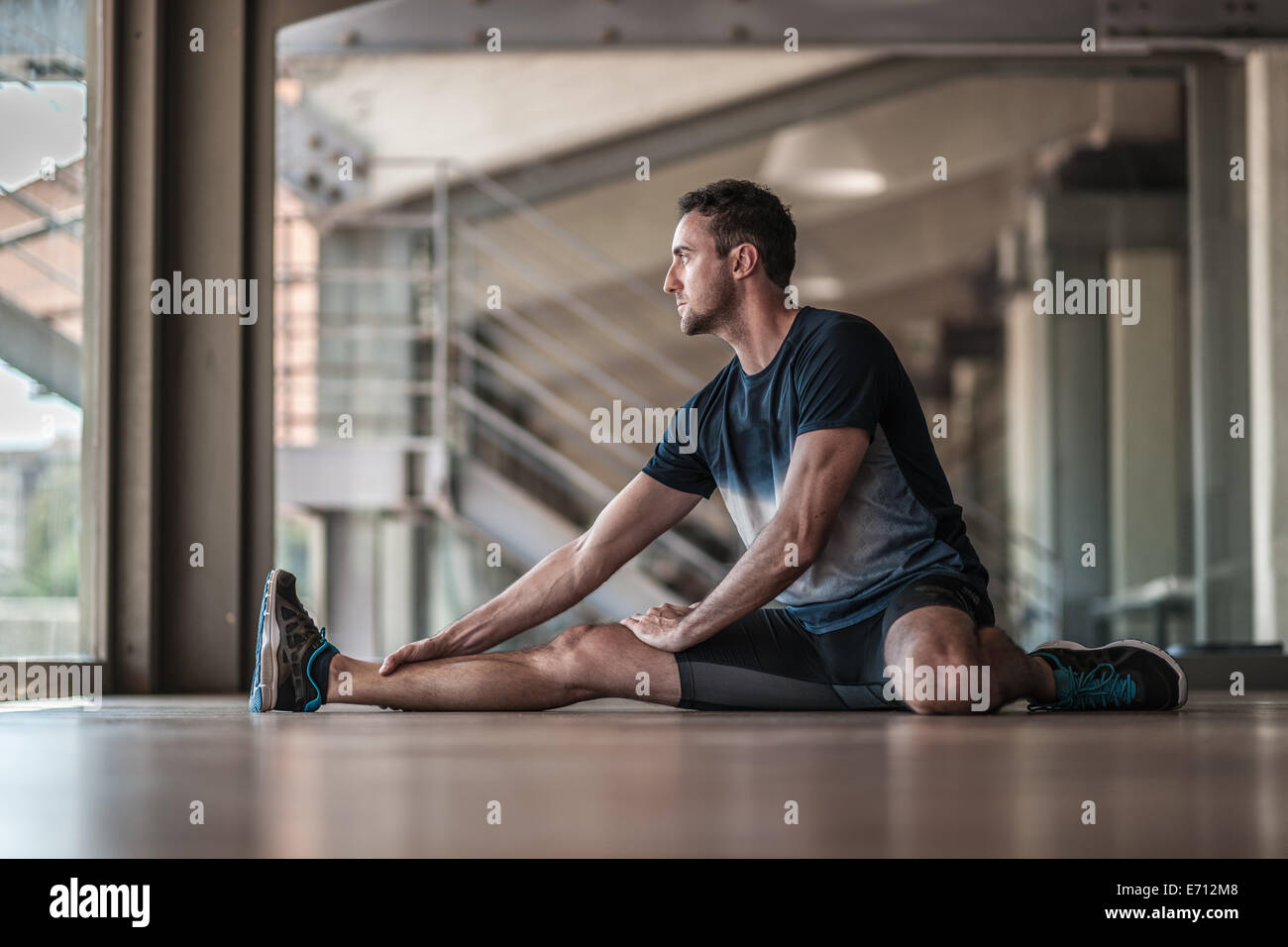 Mid adult man stretching Stock Photo - Alamy