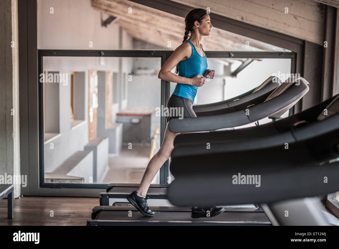 Young woman running on treadmill Stock Photo - Alamy