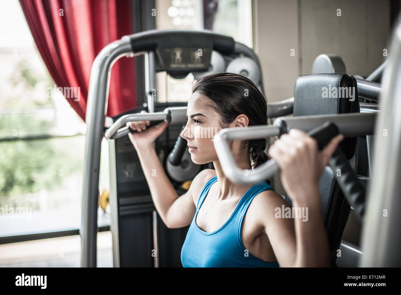 Young woman using weight equipment Stock Photo - Alamy
