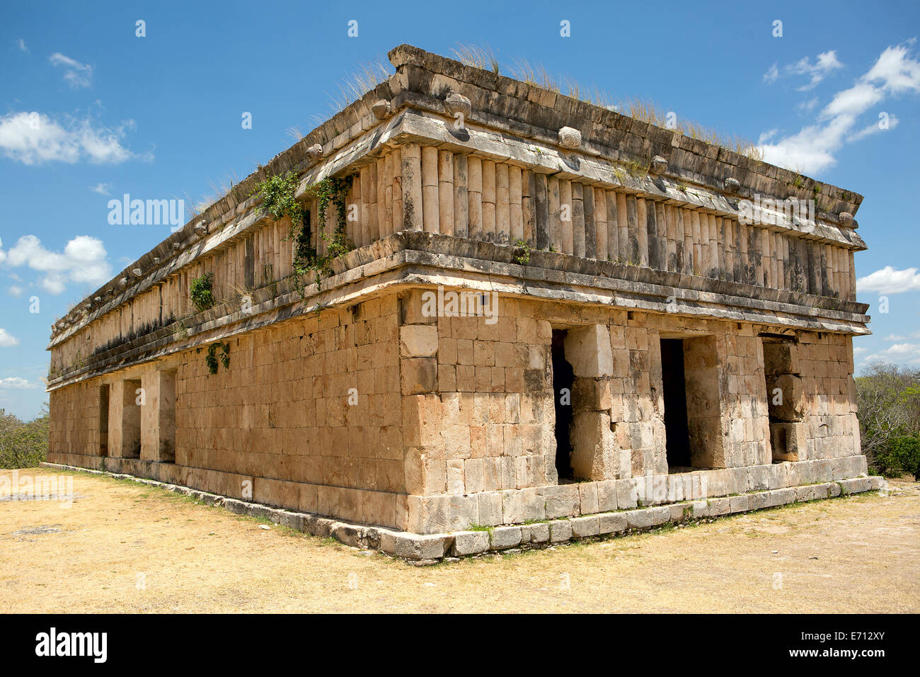abandoned ancient Mayan stone building with blue sky in the background ...
