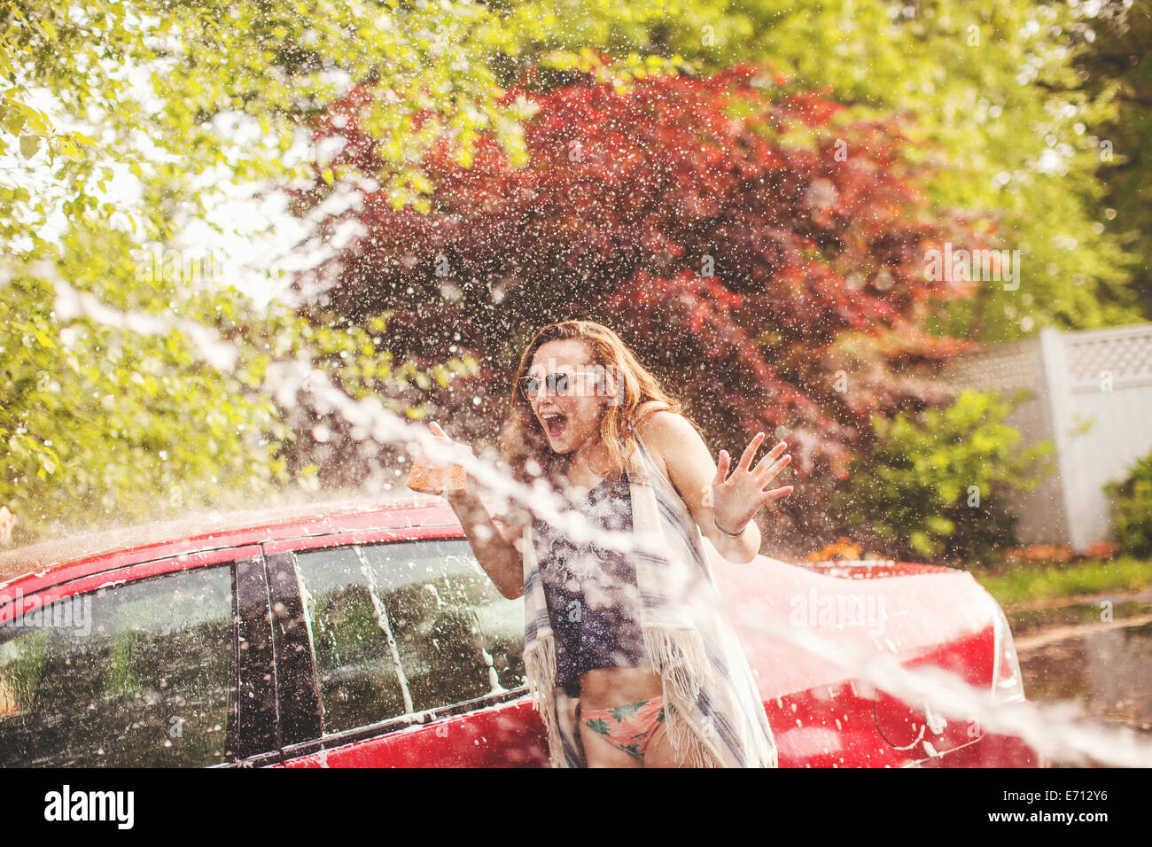 Young woman being sprayed with water Stock Photo - Alamy
