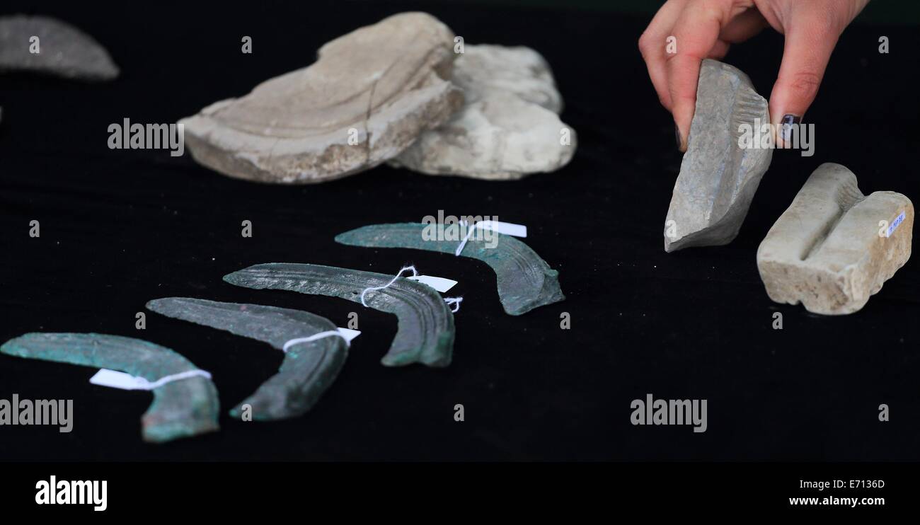 Molds and four sickles are presented at an excavation area of the State ...