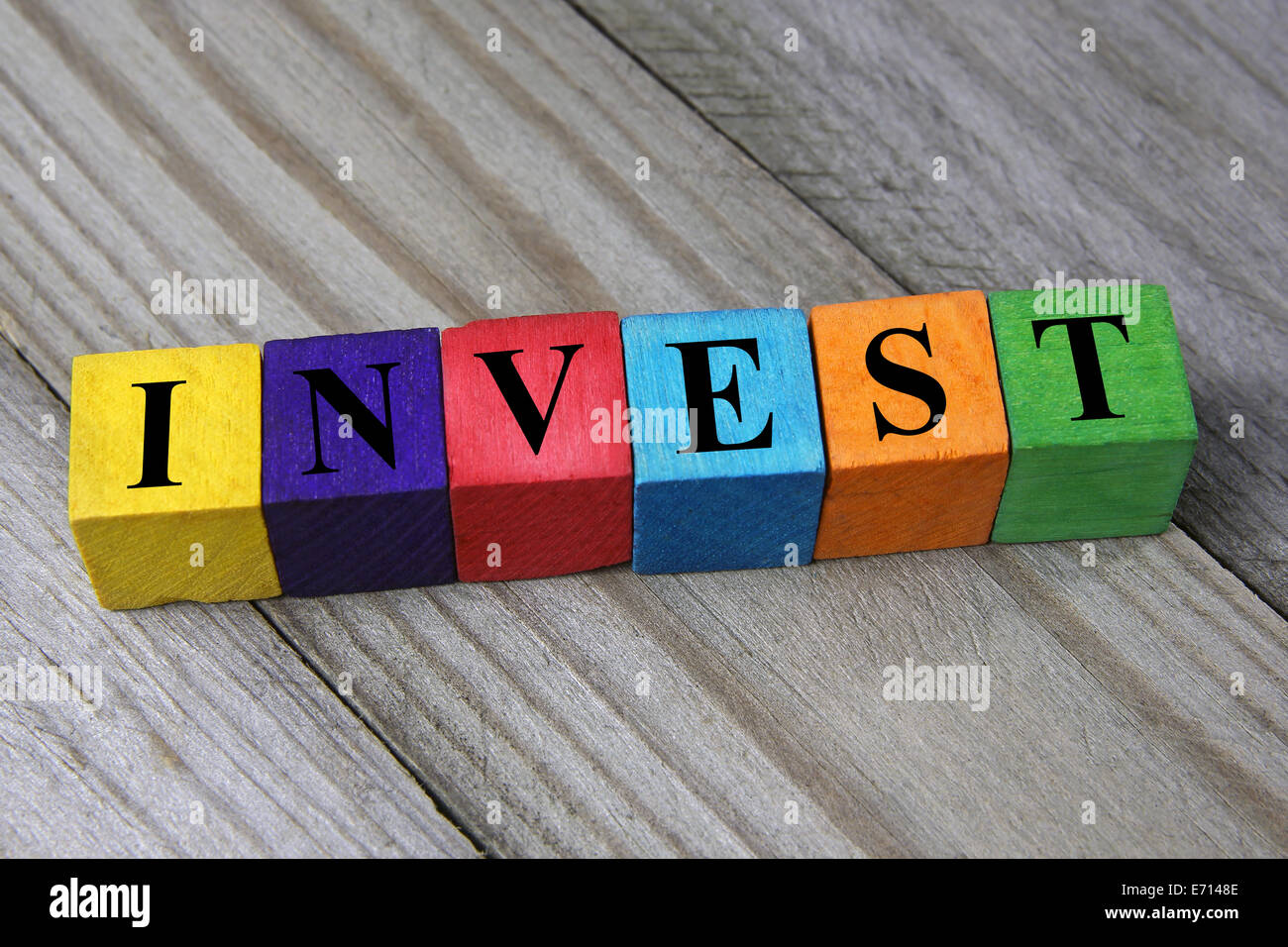 word invest on colorful wooden cubes Stock Photo - Alamy