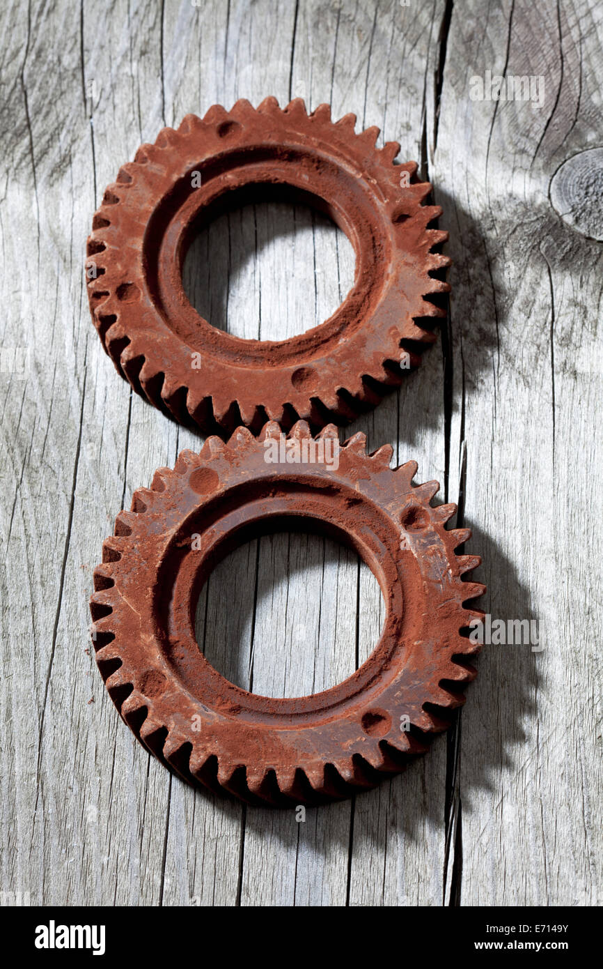 Two cog wheels made of chocolate lying on grey wood Stock Photo - Alamy