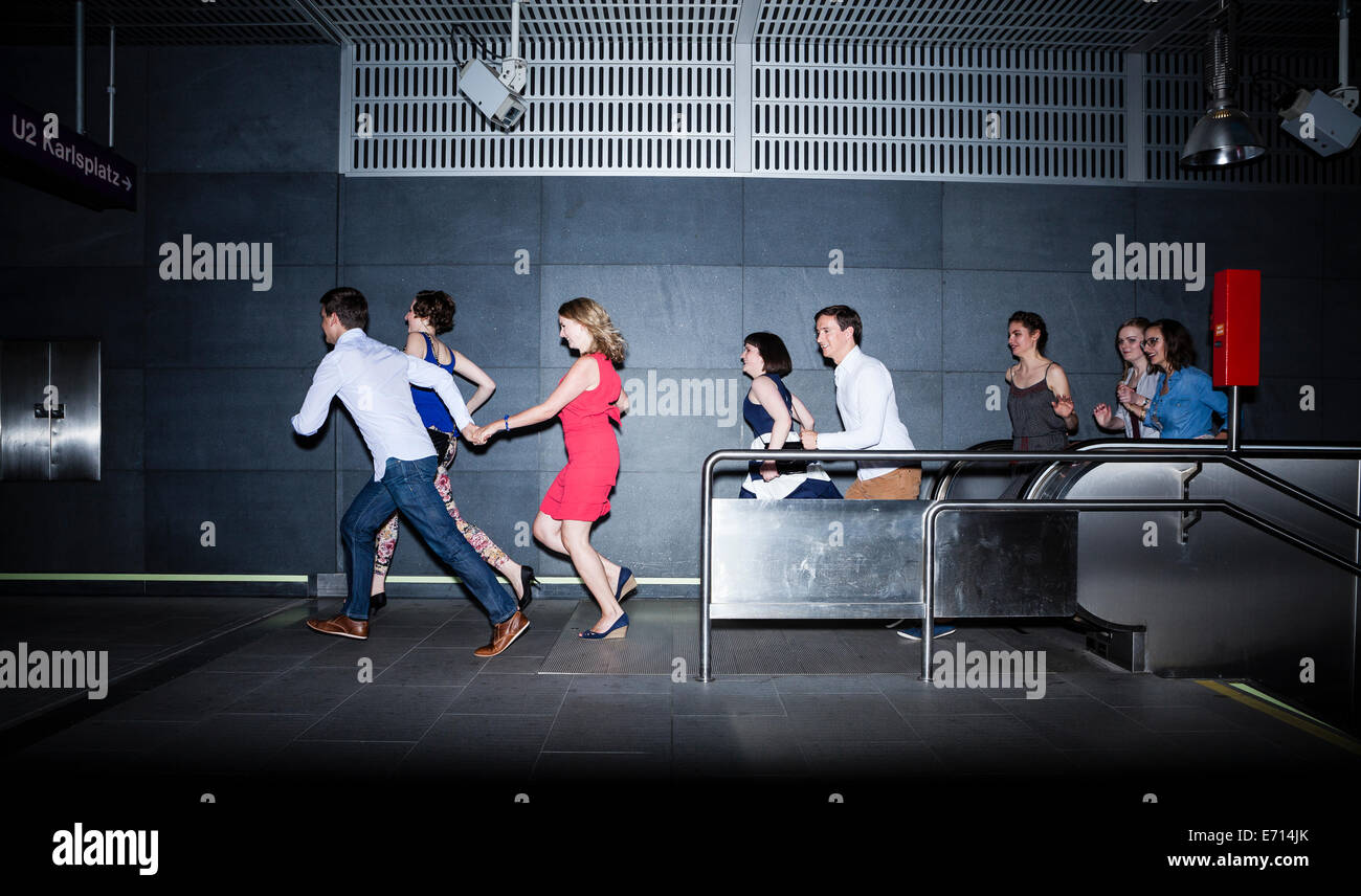 Group of friends running in subway station Stock Photo - Alamy