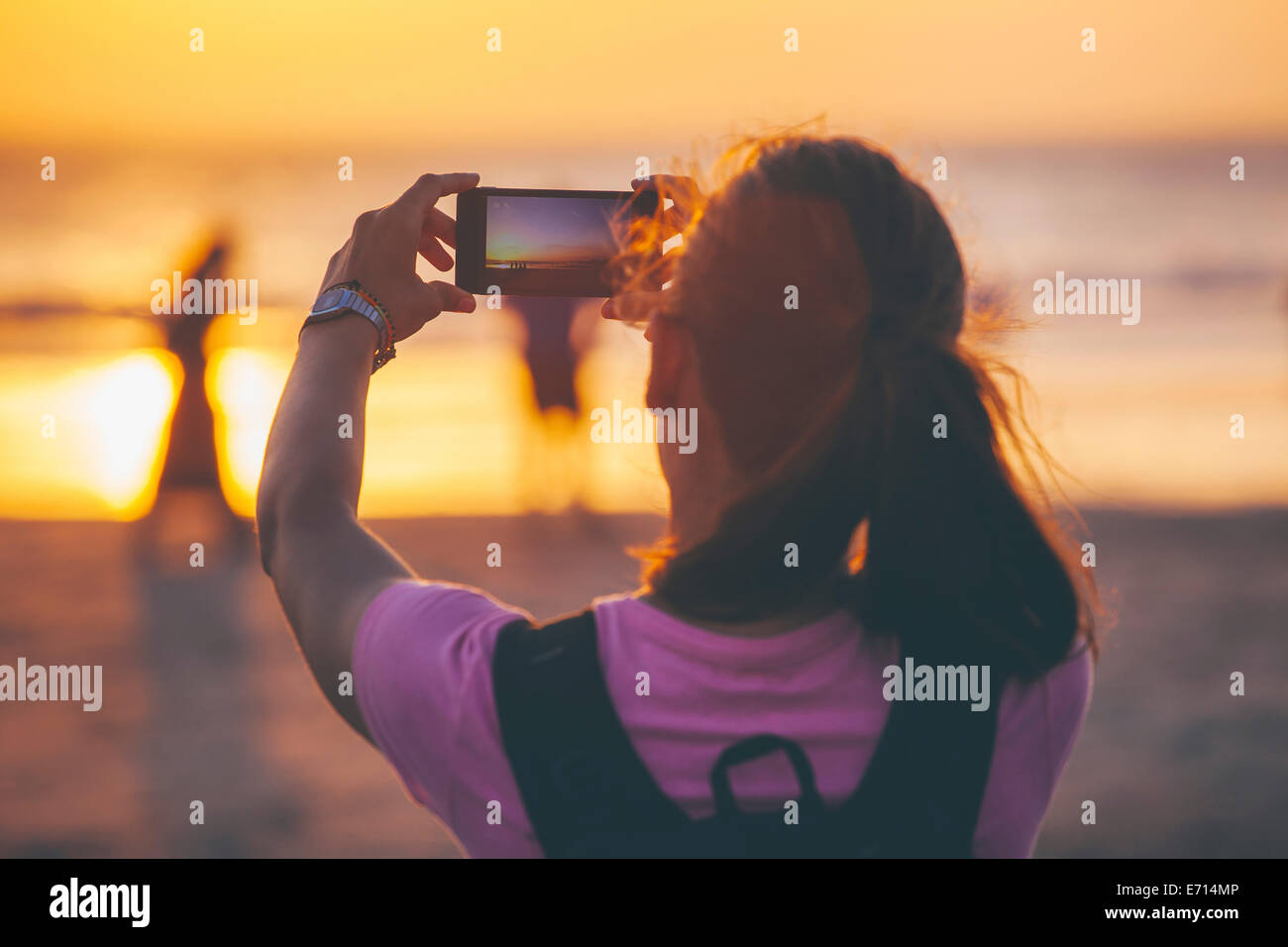 Indonesia, Bali, woman on the beach photographing sunset with her smartphone Stock Photo - Alamy