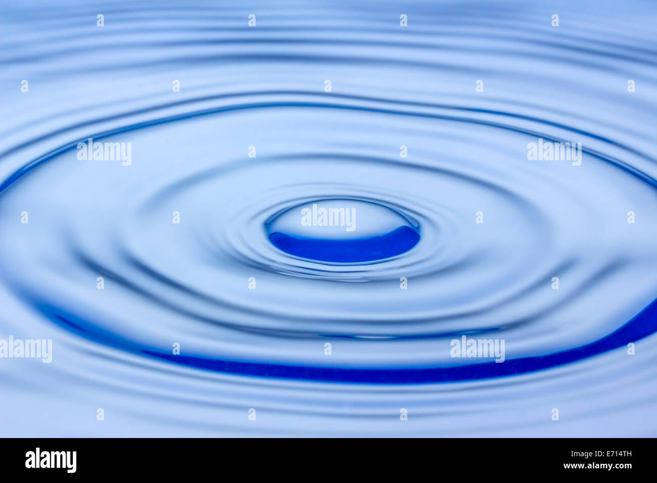Waterdrop splashing in water Stock Photo - Alamy