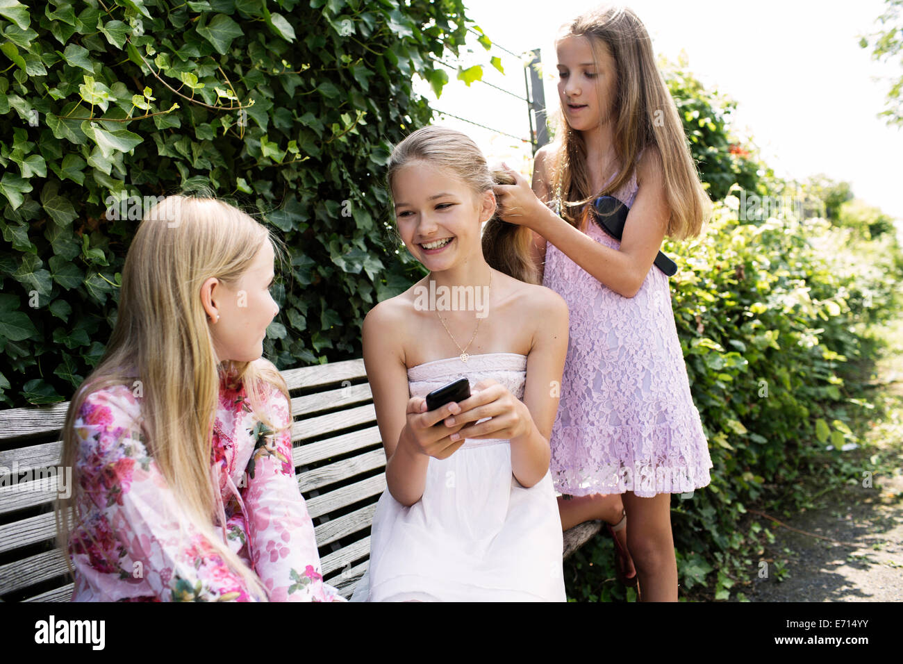 Three girls spending their time with hairdressing Stock Photo - Alamy