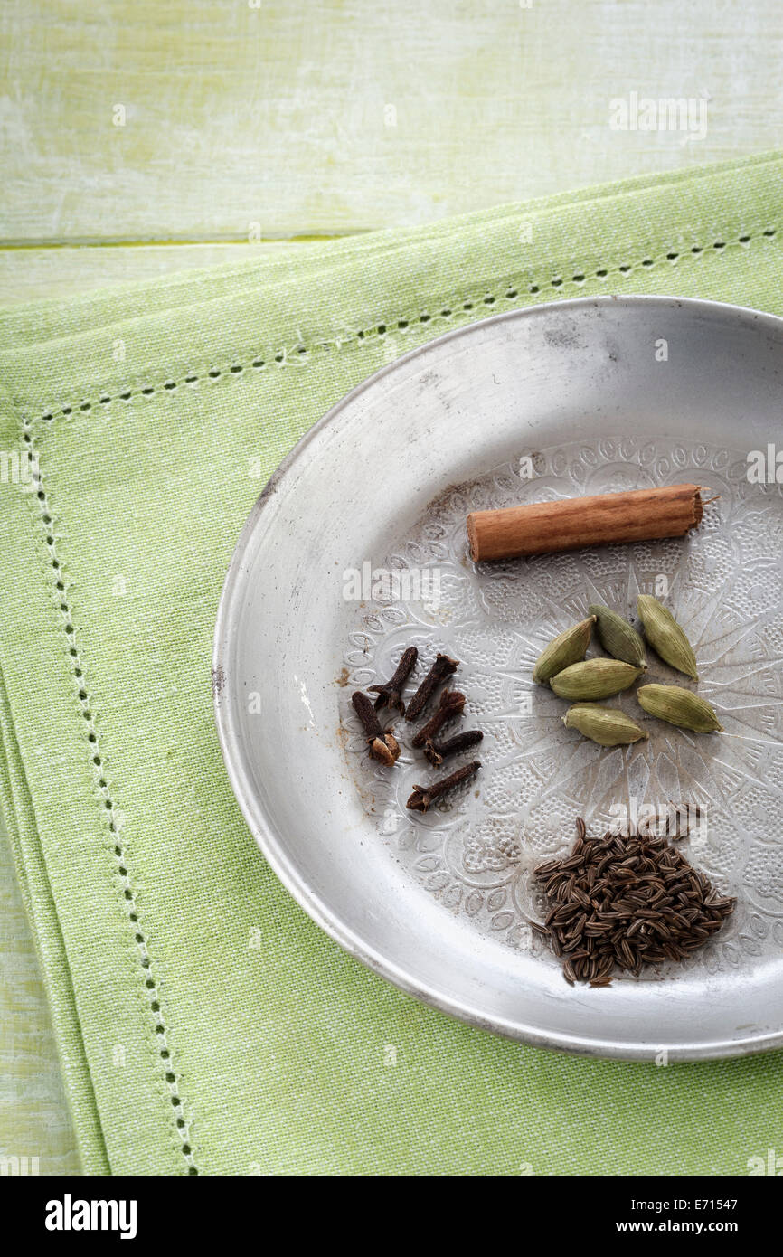 Cardamom capsules, cloves, cumin and cinnamon stick on metal plate ...