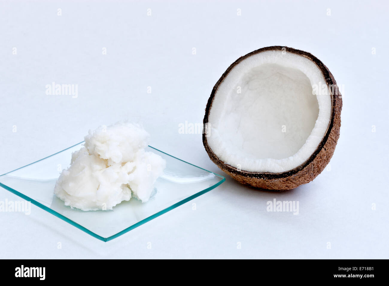 Solid coconut oil on glass tray, halved nut Stock Photo - Alamy