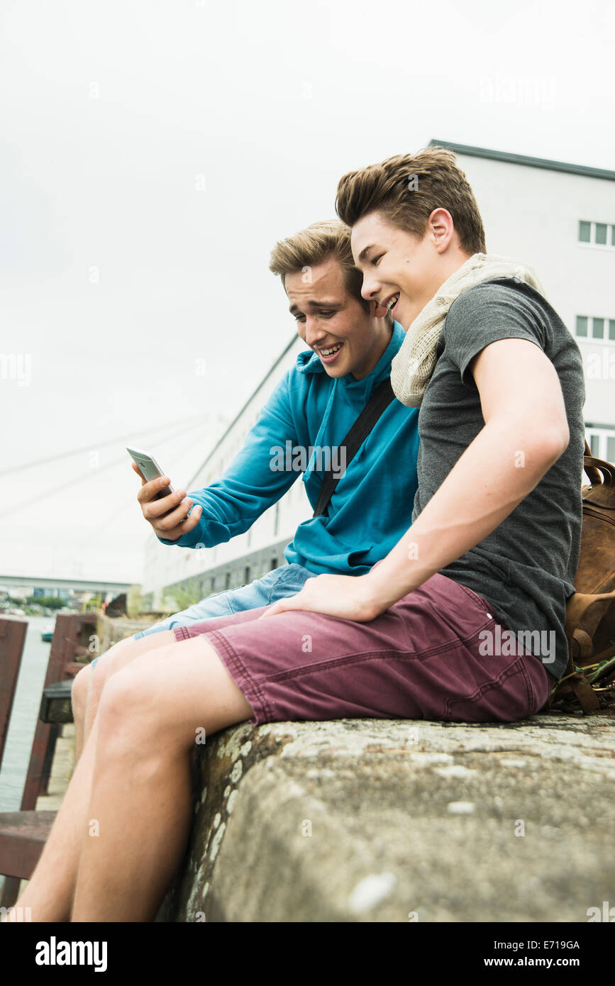Two happy friends with cell phone outdoors Stock Photo - Alamy