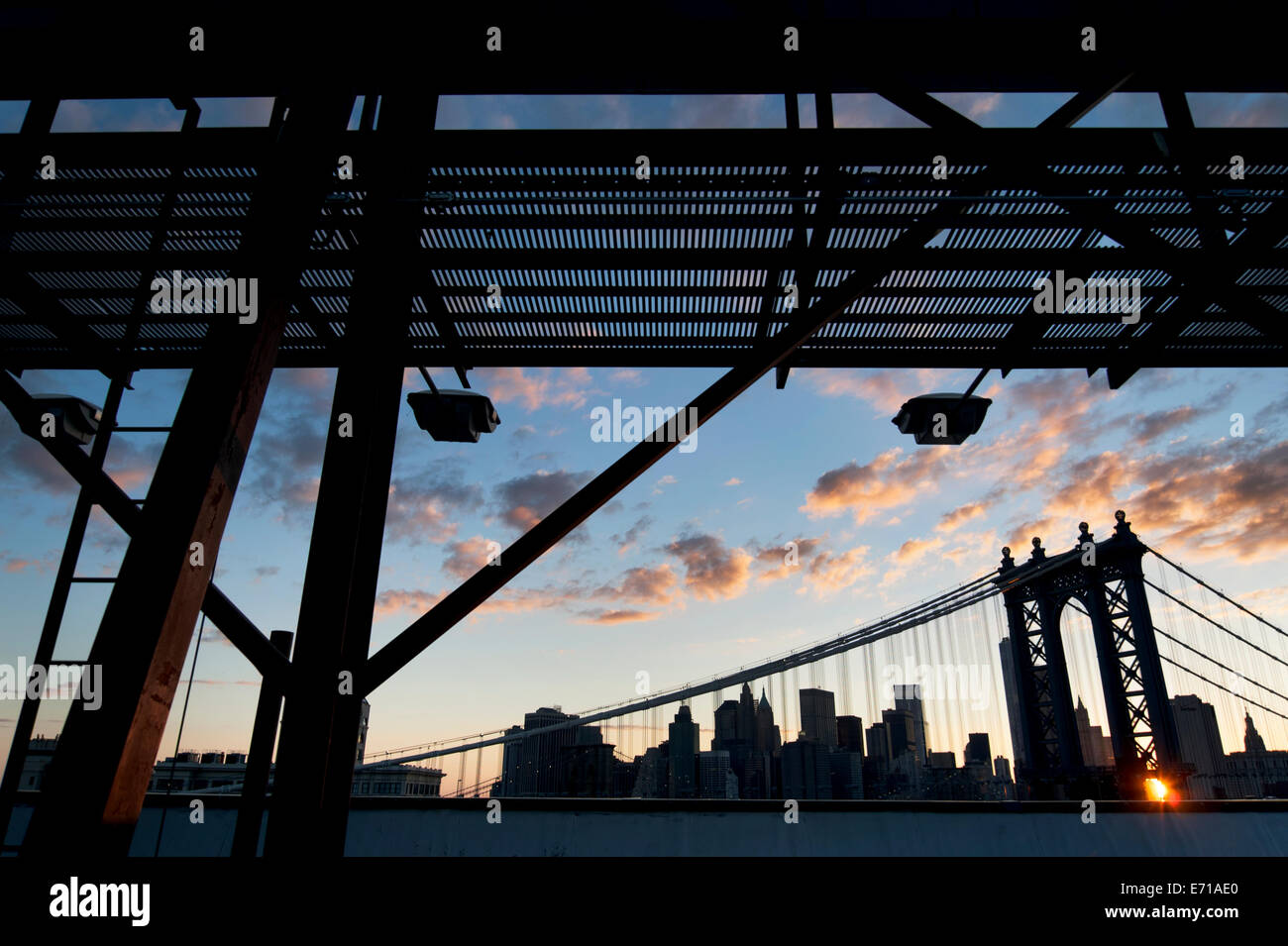 View of Manhattan Bridge at sunset from Brooklyn rooftop, framed by ...