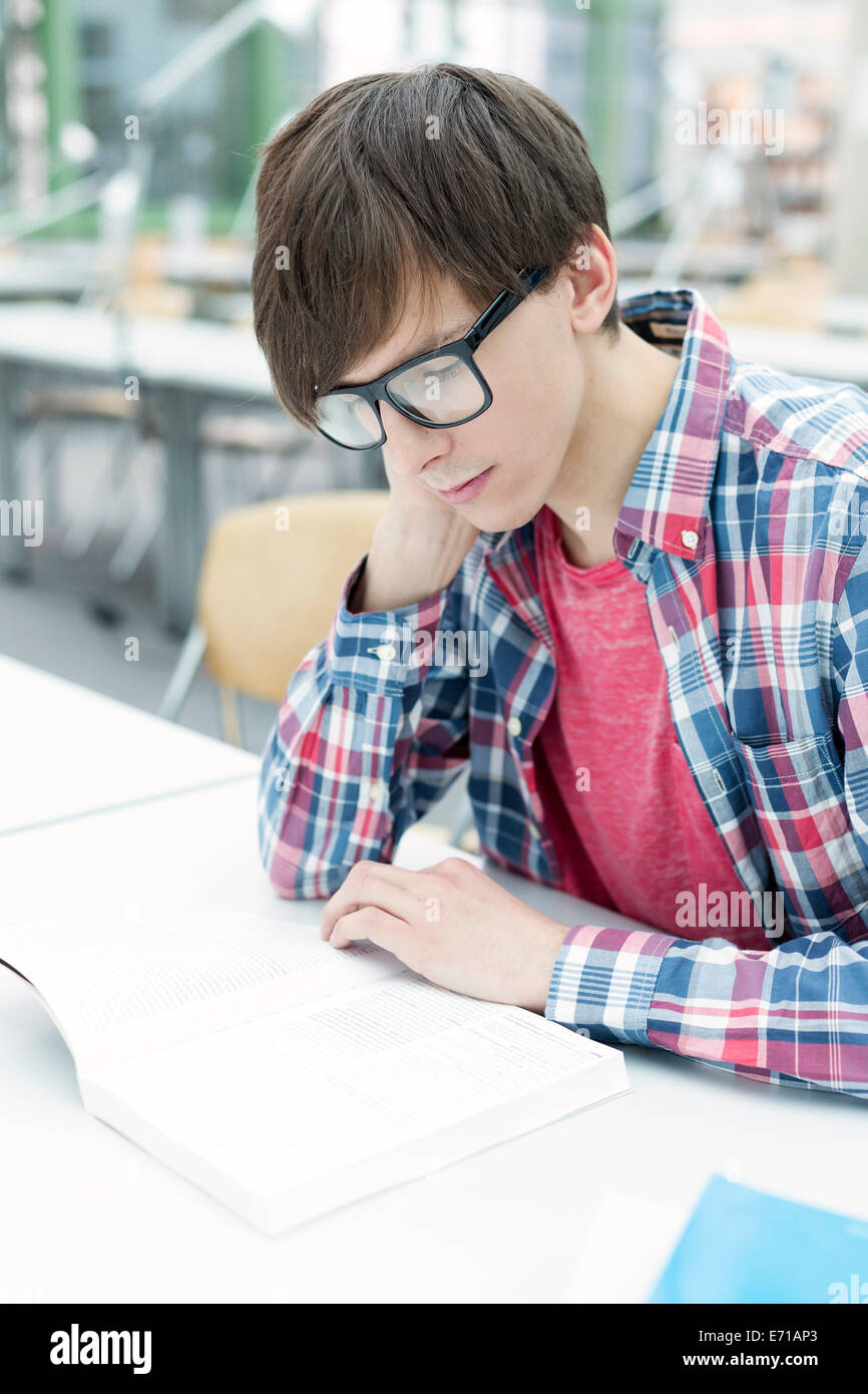Student in a university library reading book Stock Photo - Alamy