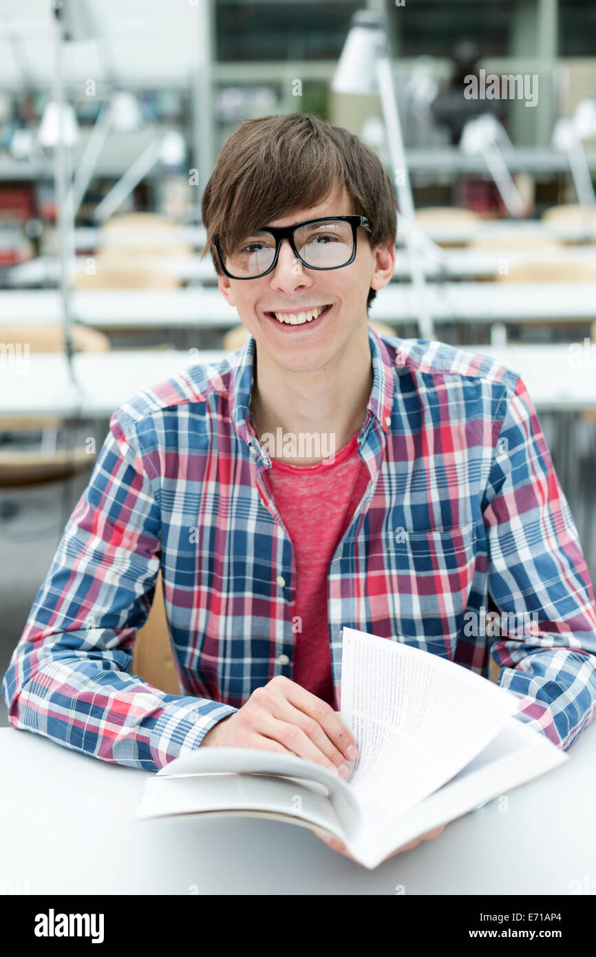 Portrait of student in a university library reading book Stock Photo ...