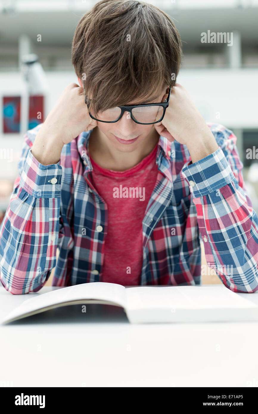 Student in a university library reading book Stock Photo - Alamy