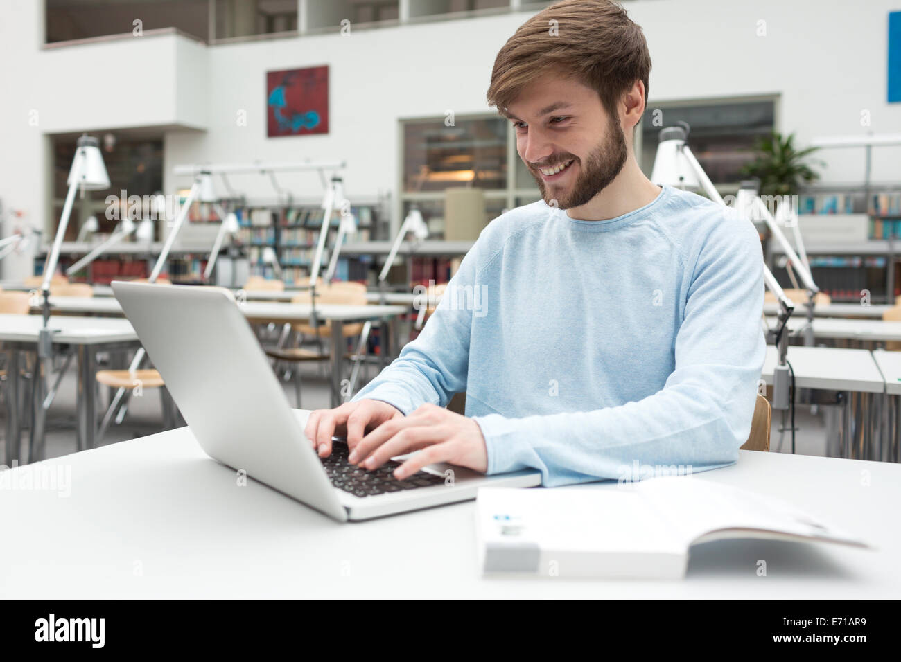 Student using laptop in a university library Stock Photo - Alamy