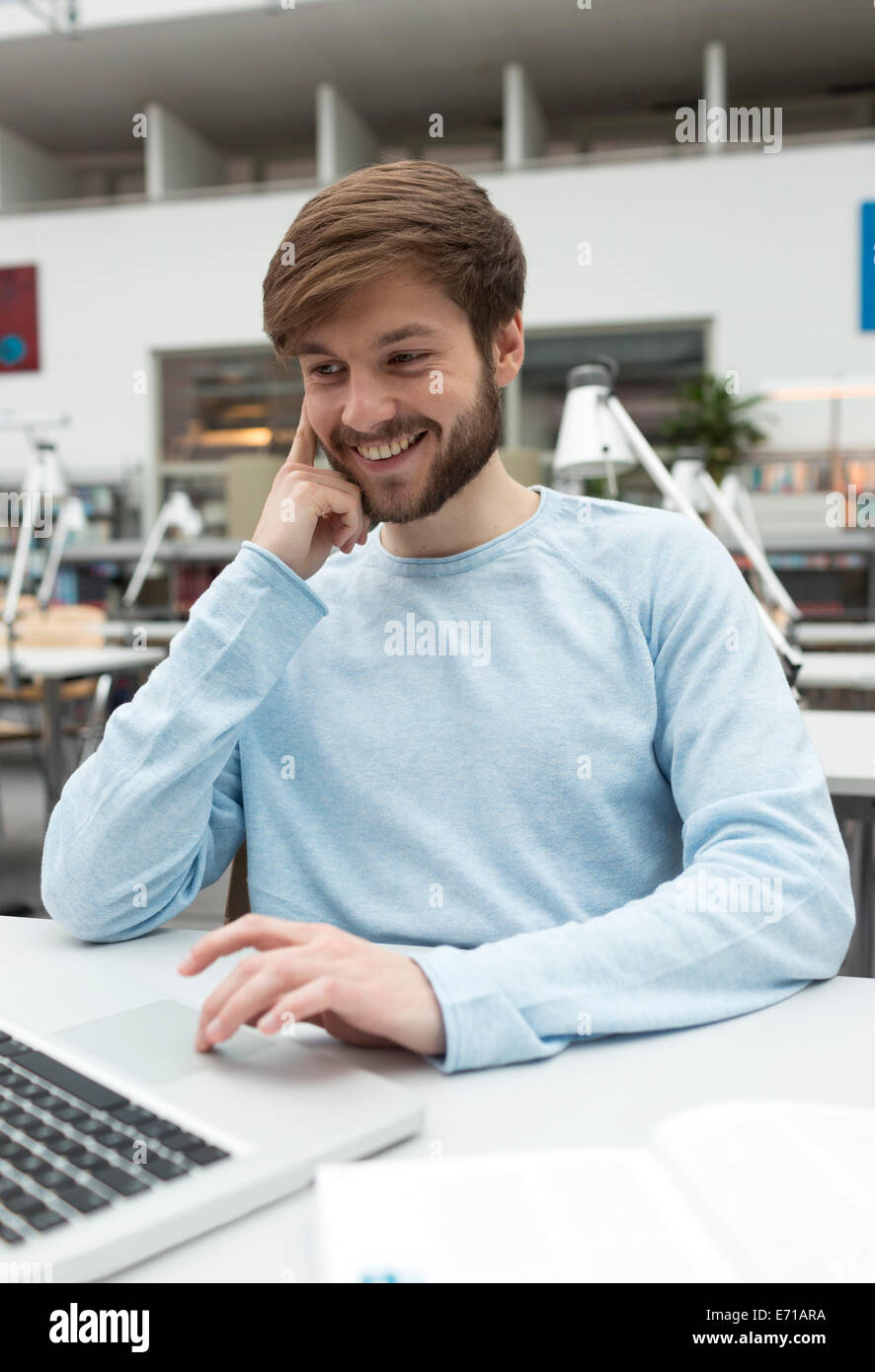 Student using laptop in a university library Stock Photo - Alamy