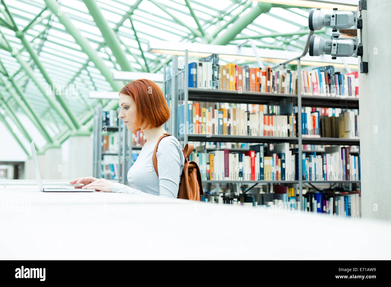 Student in a university library using laptop Stock Photo - Alamy