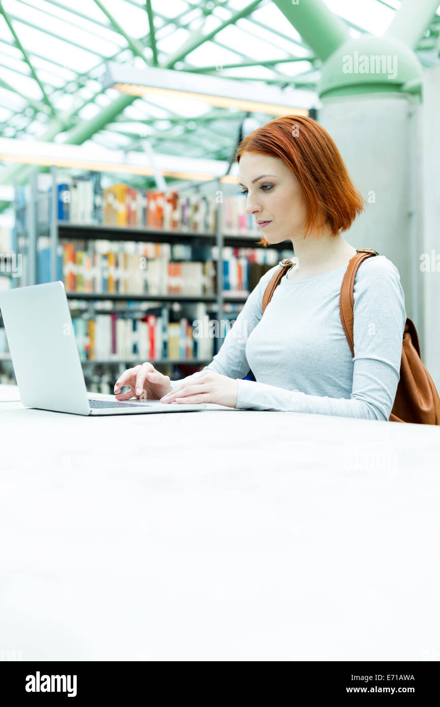Student in a university library using laptop Stock Photo - Alamy