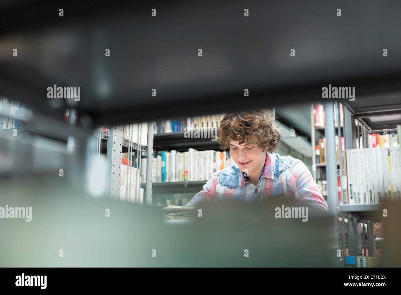 Student in a university library reading book Stock Photo - Alamy